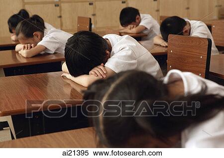 Stock Image of Elementary school children with heads down on desk ...