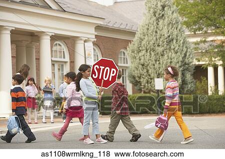 Pictures of Student crossing guard holding stop sign while children ...