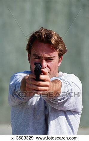 Stock Photograph of Man shooting, front view x13583329 - Search Stock ...