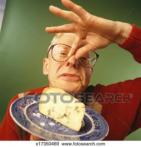 Stock Photograph of Man holding plate with wedge of stinky blue cheese ...