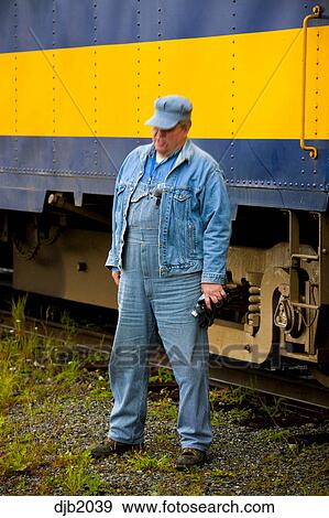 Stock Photograph of Railroad engineer standing in front of train with ...