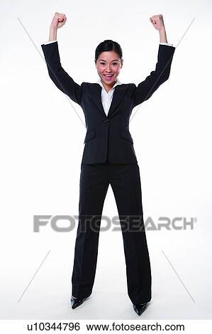 Young woman in business suit, standing, arms raised Stock Photograph ...