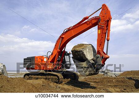 Stock Photo of Crawler excavator placing rocks during construction of ...